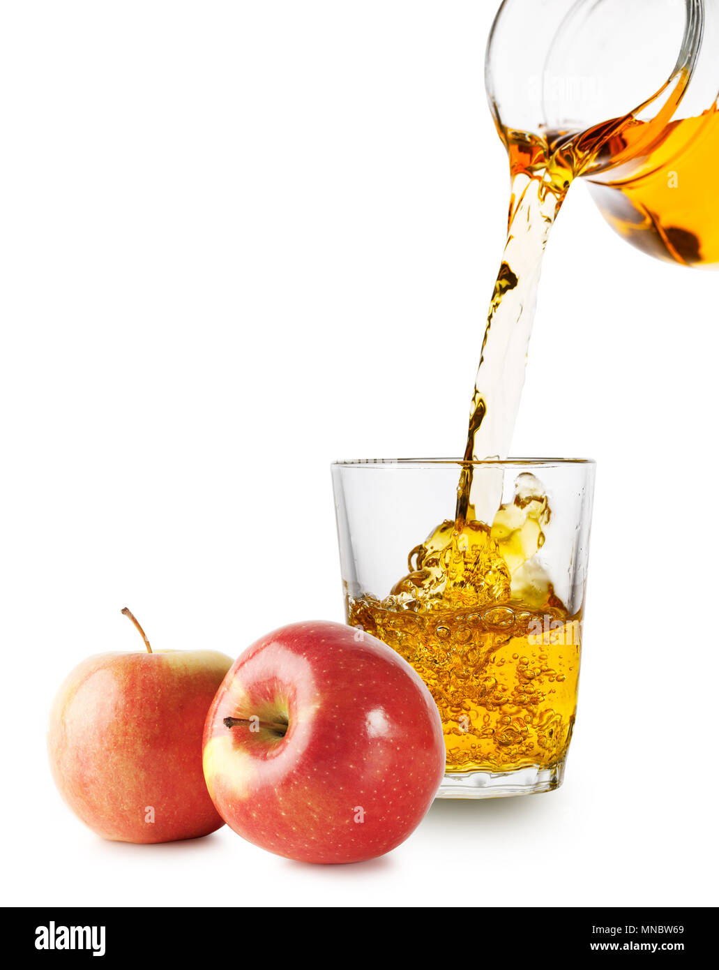 Glass with pouring apple juice and red apples isolated on white ...