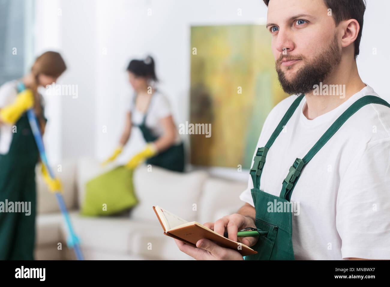 Young handsome cleaning man in uniform planning new job Stock Photo - Alamy