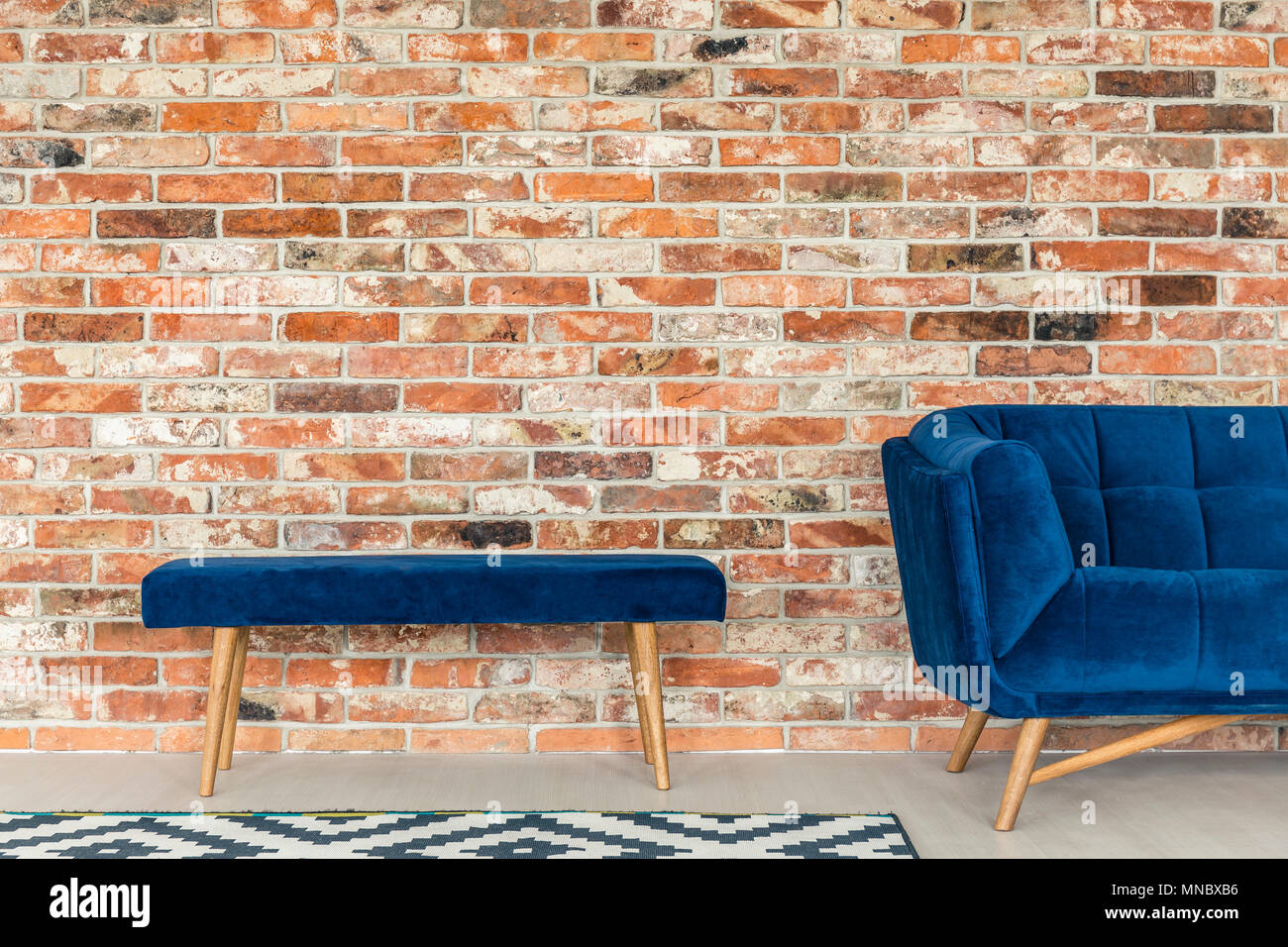 Red brick wall, blue upholstered bench and sofa Stock Photo - Alamy