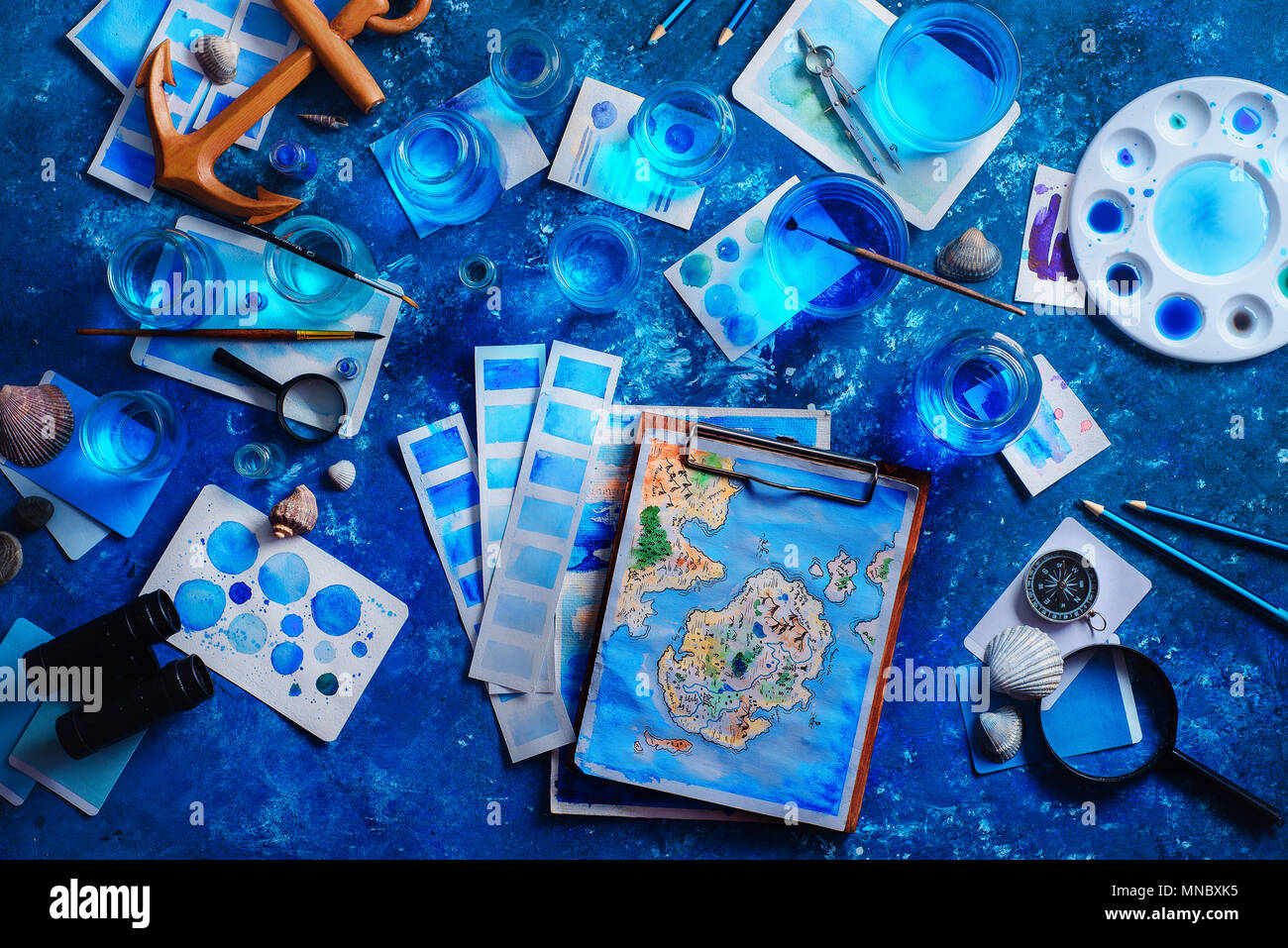 Fantasy maps on a wooden clipboard in an artist workplace with sketches ...