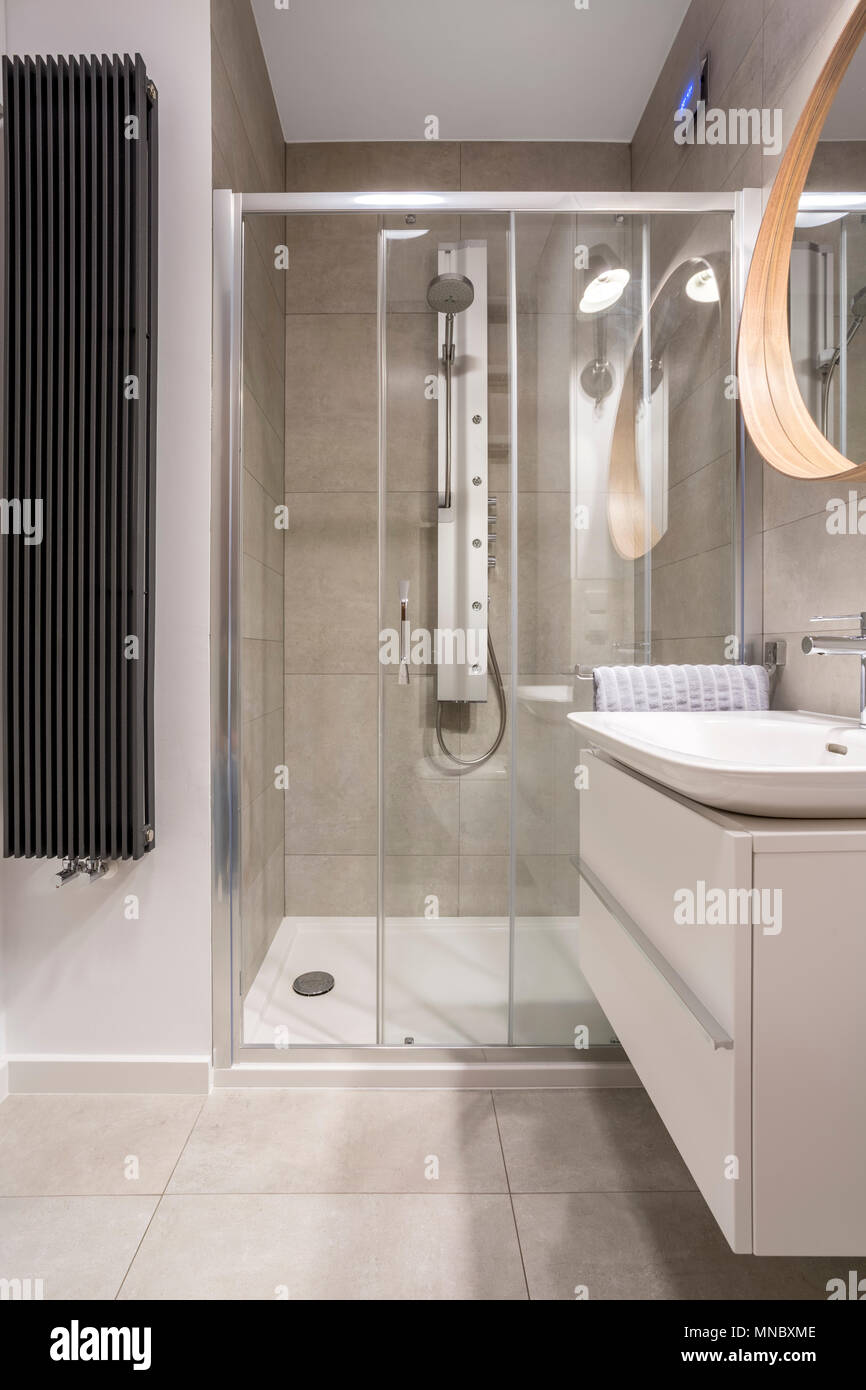 Light bathroom with walk in shower and grey tiles Stock Photo - Alamy