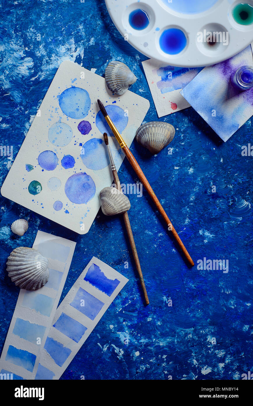 Creative artist workplace with marine watercolor, palettes, swatches ...