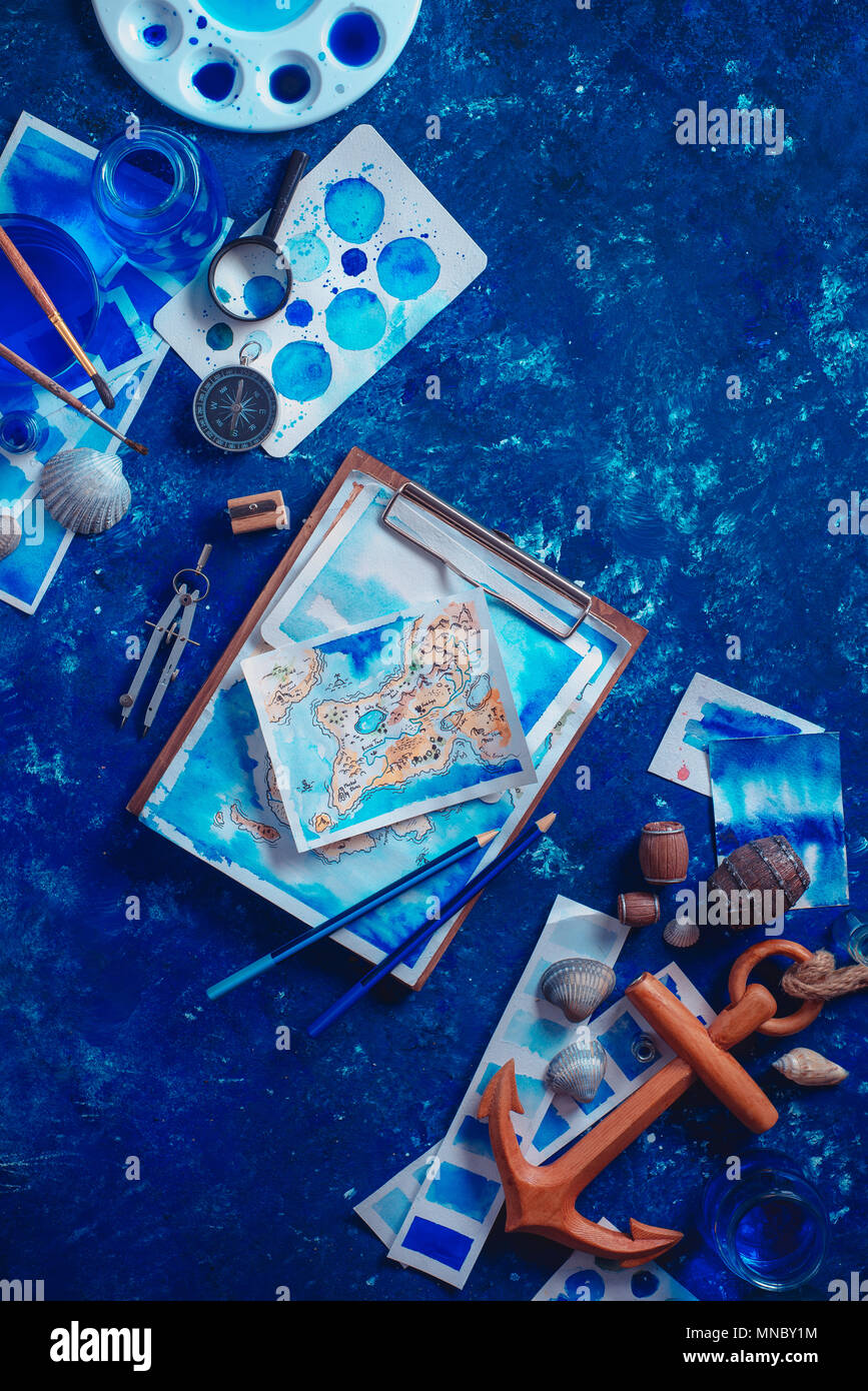 Fantasy maps on a wooden clipboard in an artist workplace with sketches ...