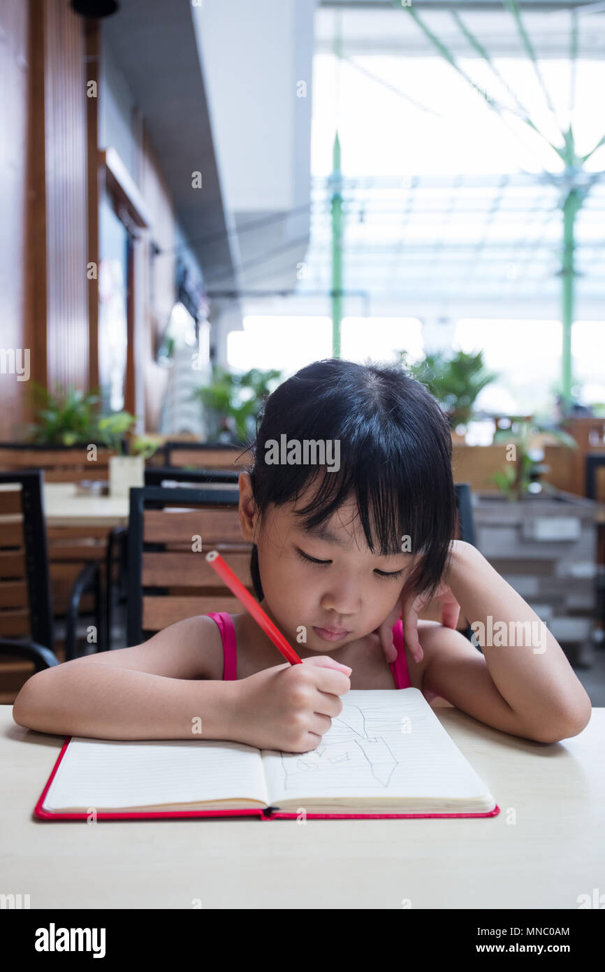 Asian Chinese little girl doing homework at outdoor cafe Stock Photo ...