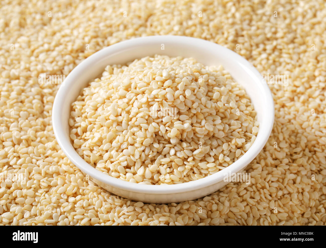 bowl of healthy sesame seeds on sesame seeds background Stock Photo - Alamy