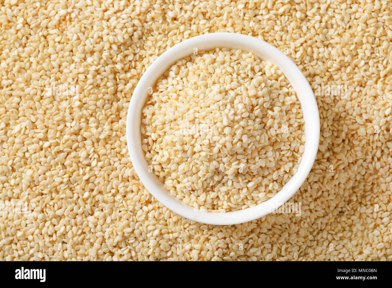 bowl of healthy sesame seeds on sesame seeds background Stock Photo - Alamy