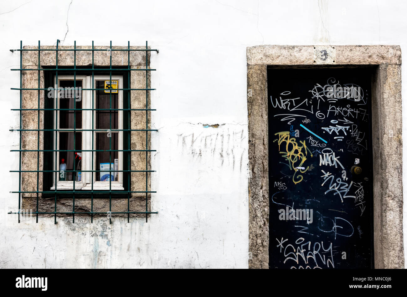 Door and barred window of a small house in an alleyway in Bairro Alto ...