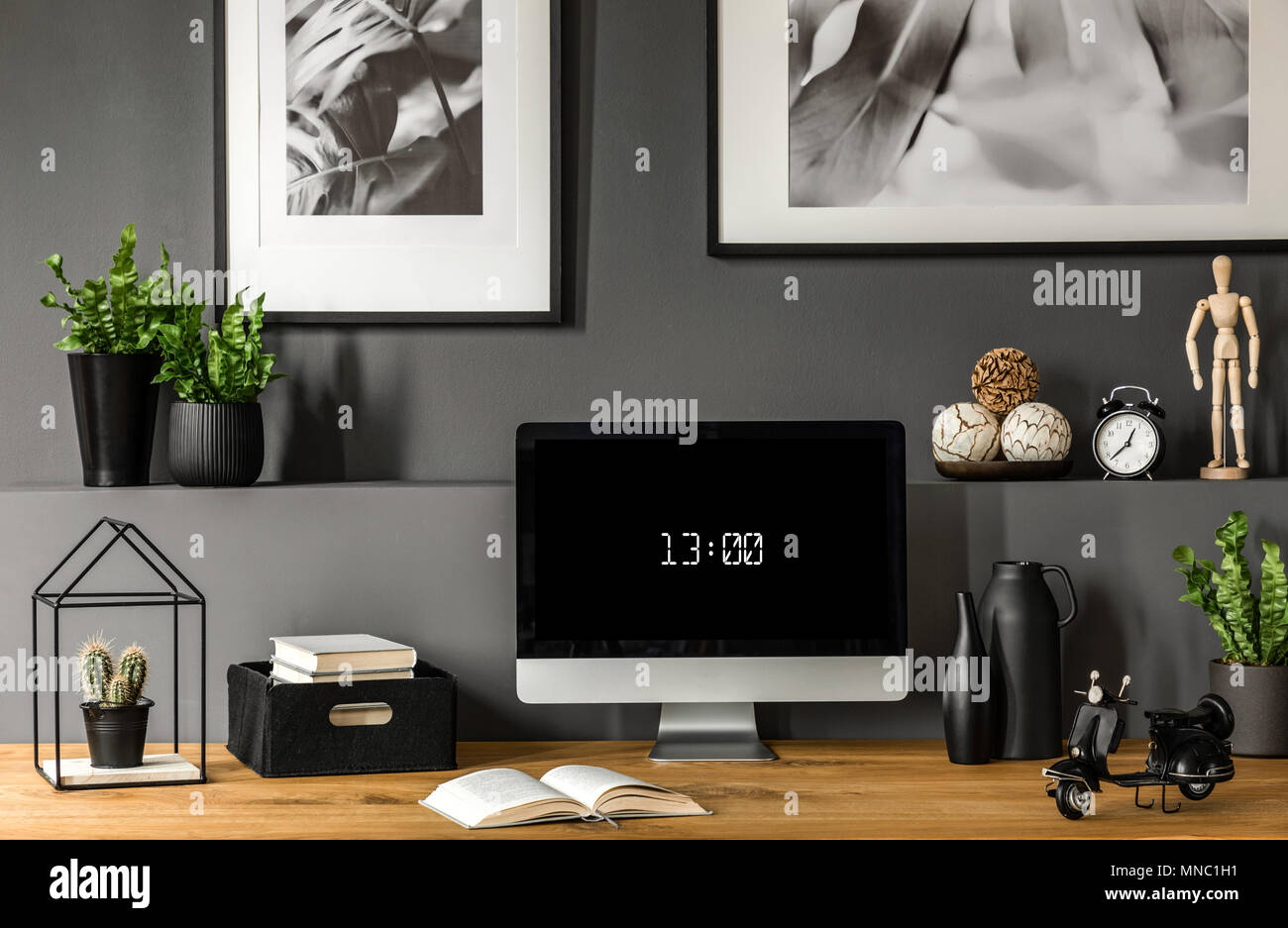 Close-up of wooden workspace with computer monitor showing the time ...