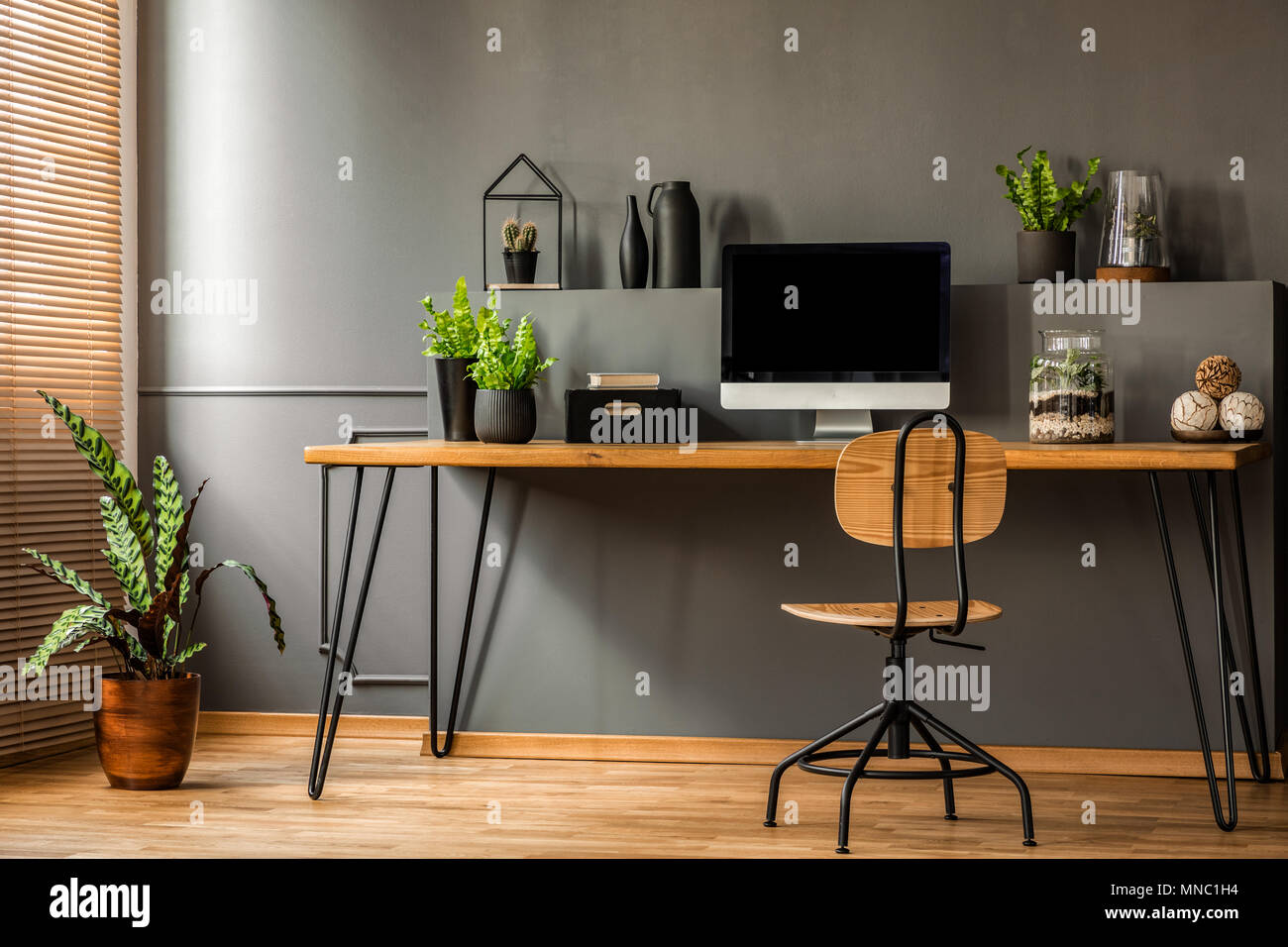 Simple workspace interior with wooden chair at the desk standing ...