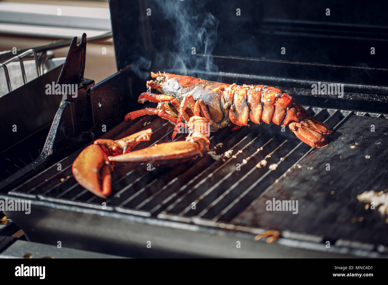 Lobster grilled barbecued seafood in BBQ Flames. cooking process Stock ...