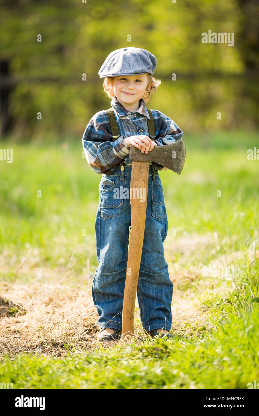 Small caucasian boy in hat posing with big axe. Portrait of small ...