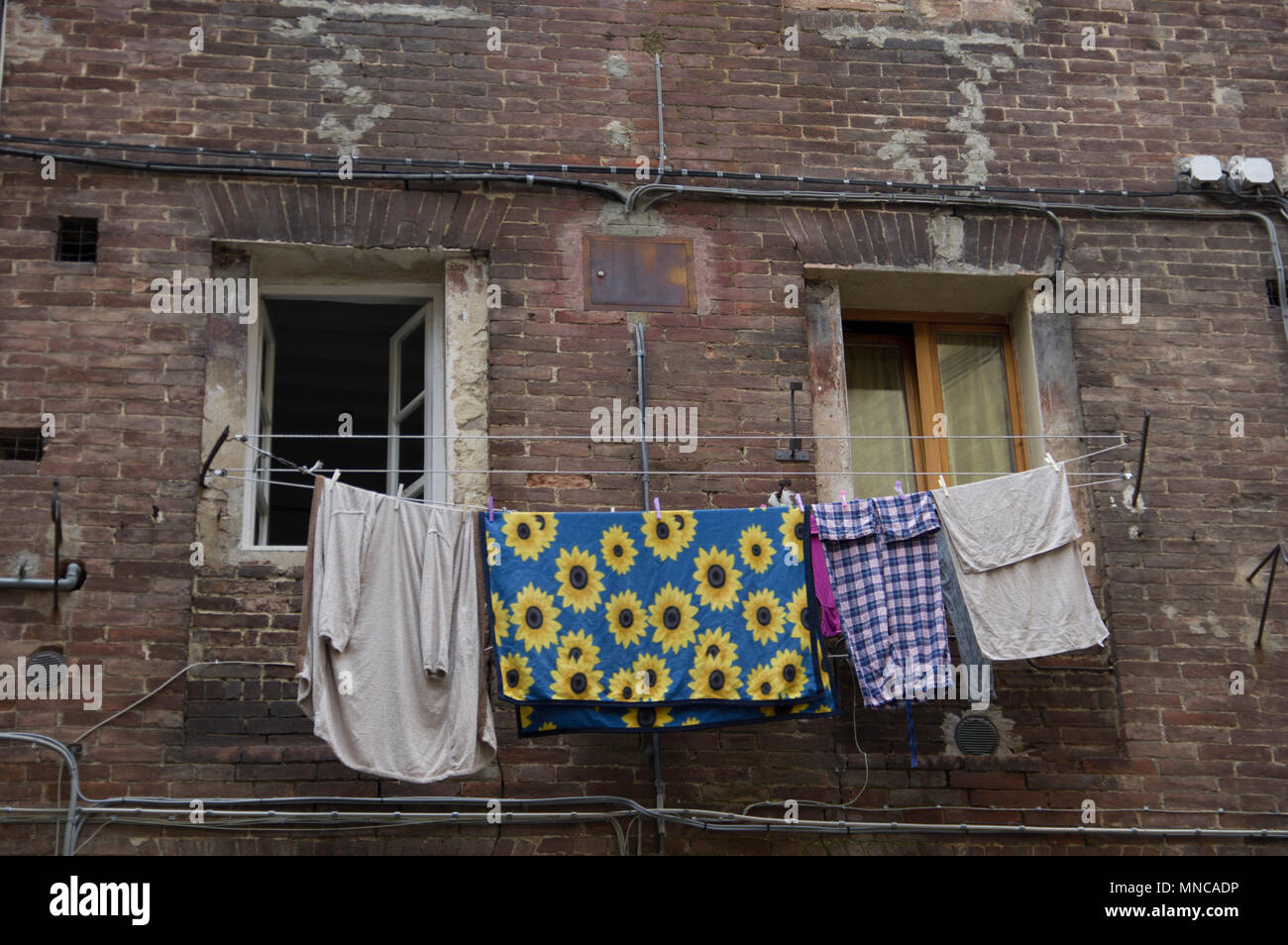 clothes hanging out to dry on a washing line in siena, Italy on an old ...