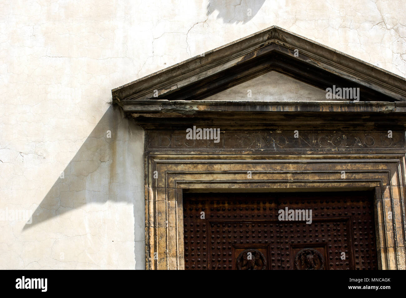 Sunlit corner of a medieval wooden door frame and capital in Florence ...