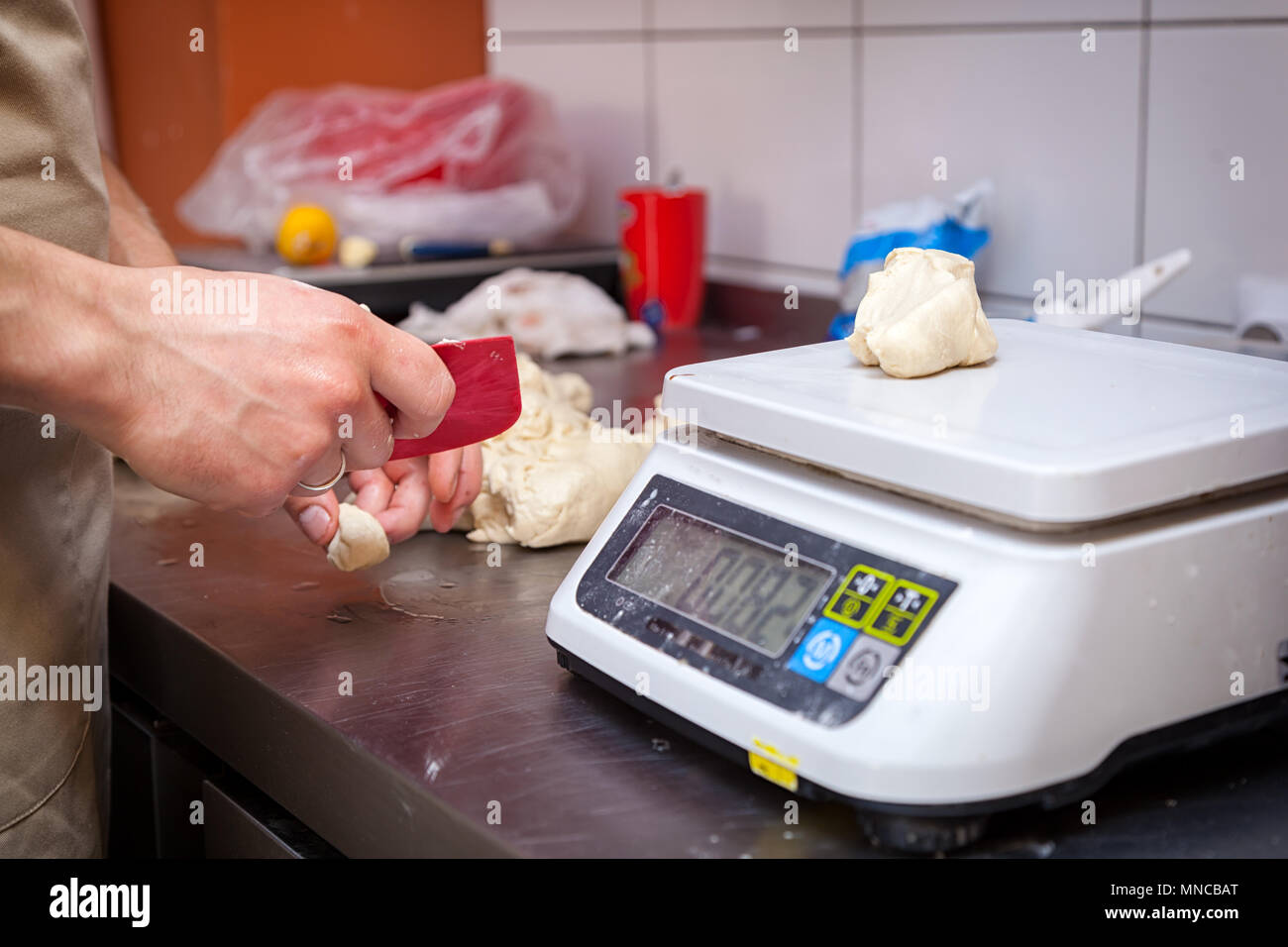 Male baker weighing ball of bread dough in bakery Stock Photo - Alamy