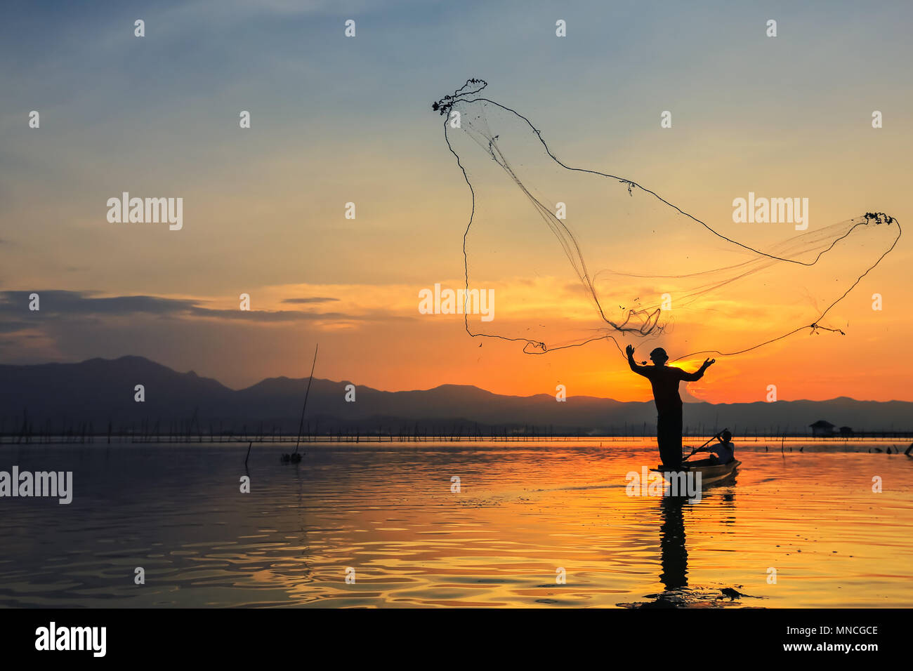 Man Throwing Fishing Net Into Water Stock Photos & Man Throwing Fishing ...