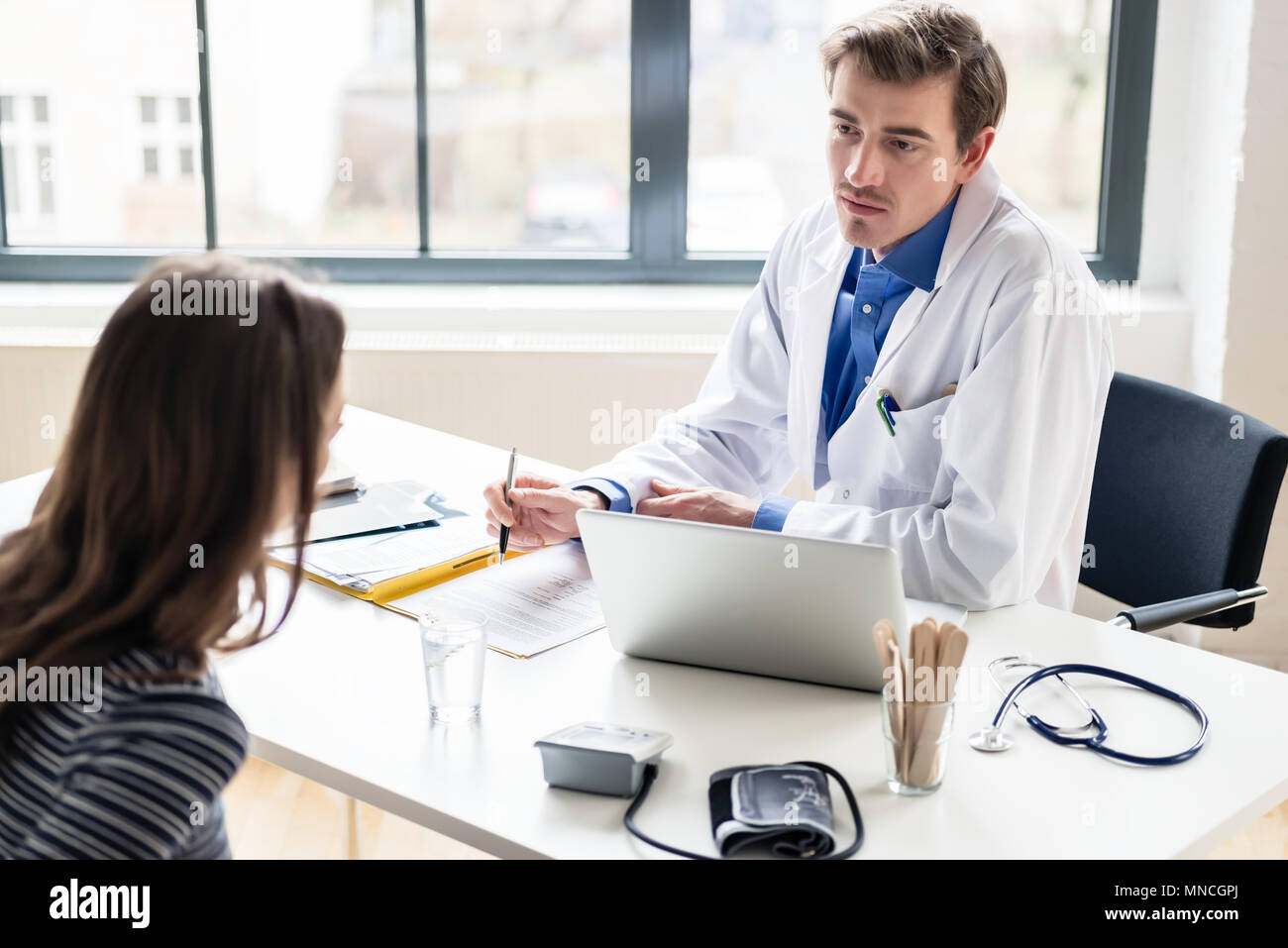 Young physician listening to his patient with respect and dedication ...