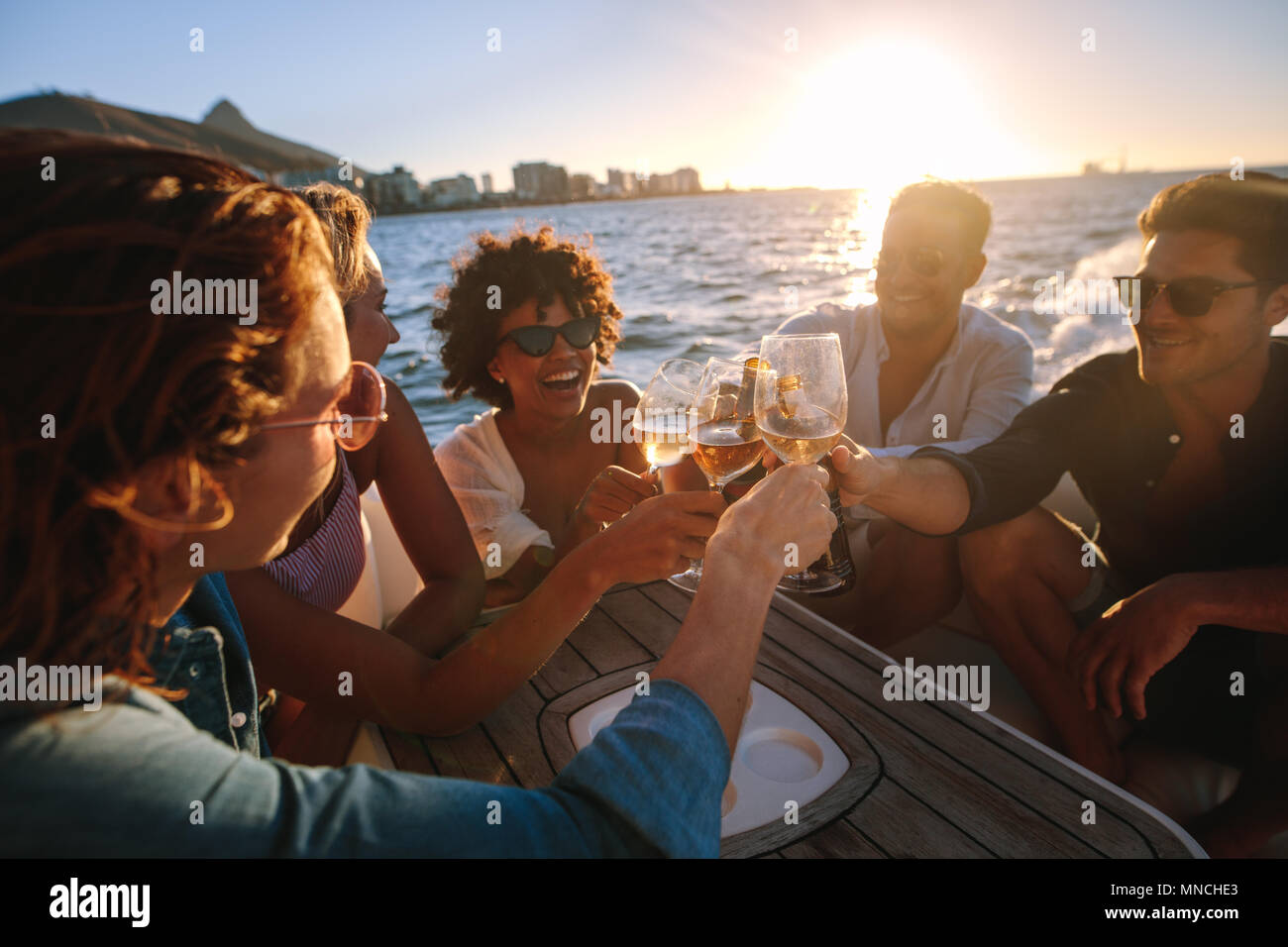 Cheerful young people on yacht drinking together. Group of friends ...