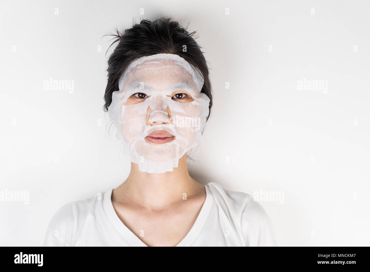 Asian girl with facial paper masking for beauty on white background ...