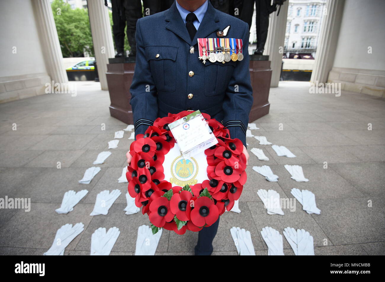 Flight Lieutenant Nigel Painter holds a wreath as he stands among 53 ...