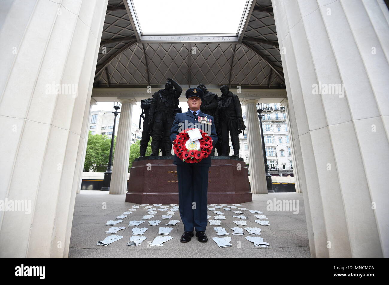 Flight Lieutenant Nigel Painter holds a wreath as he stands among 53 ...