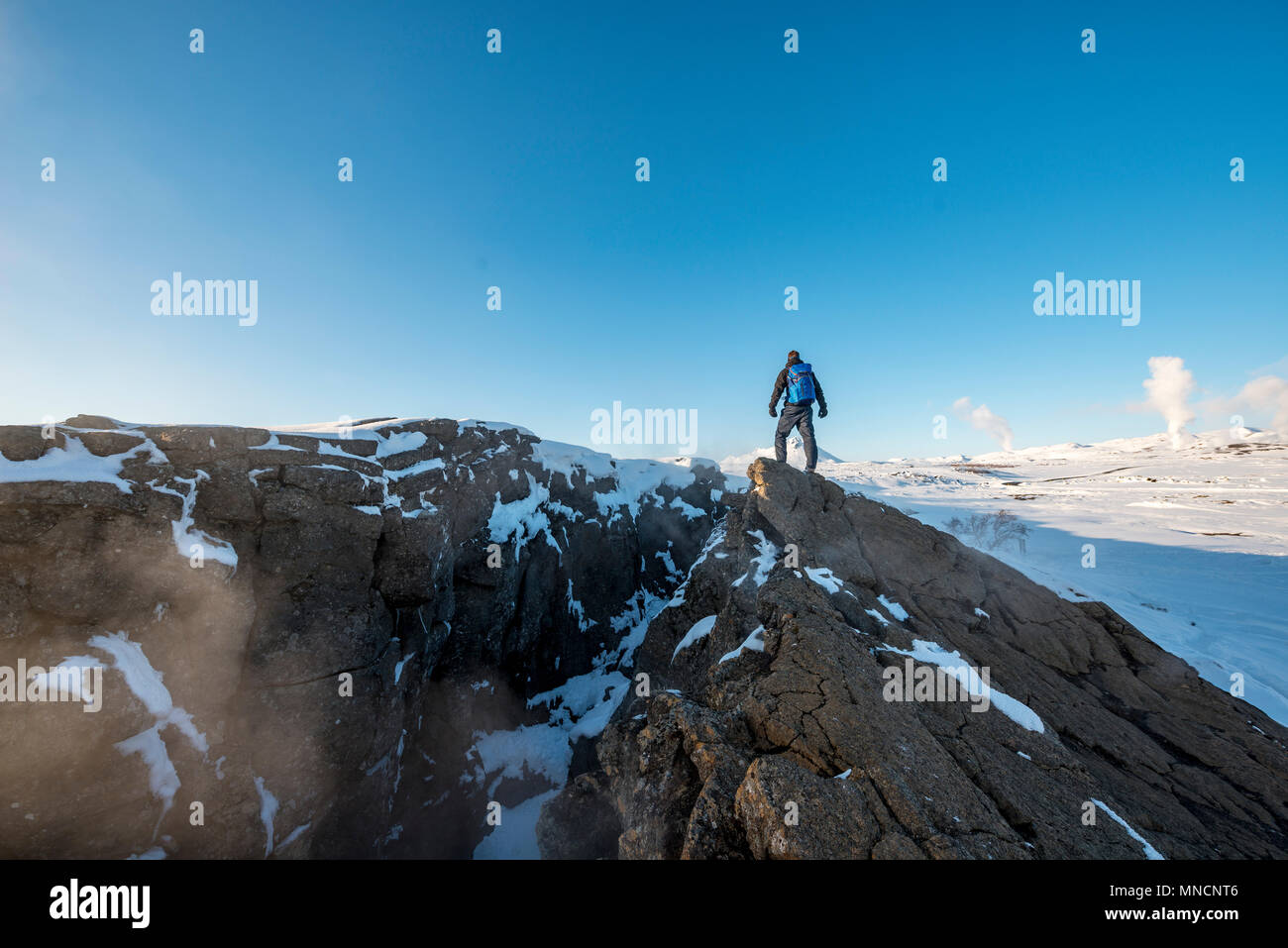 Mountain hiker stands at Continental Rift between North American and ...
