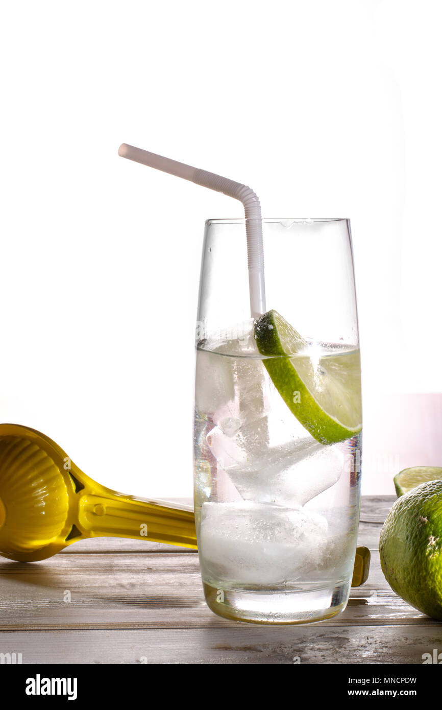 Stil mineral drink water in glass bottle served with three glasses with ice cubed, lime and ...