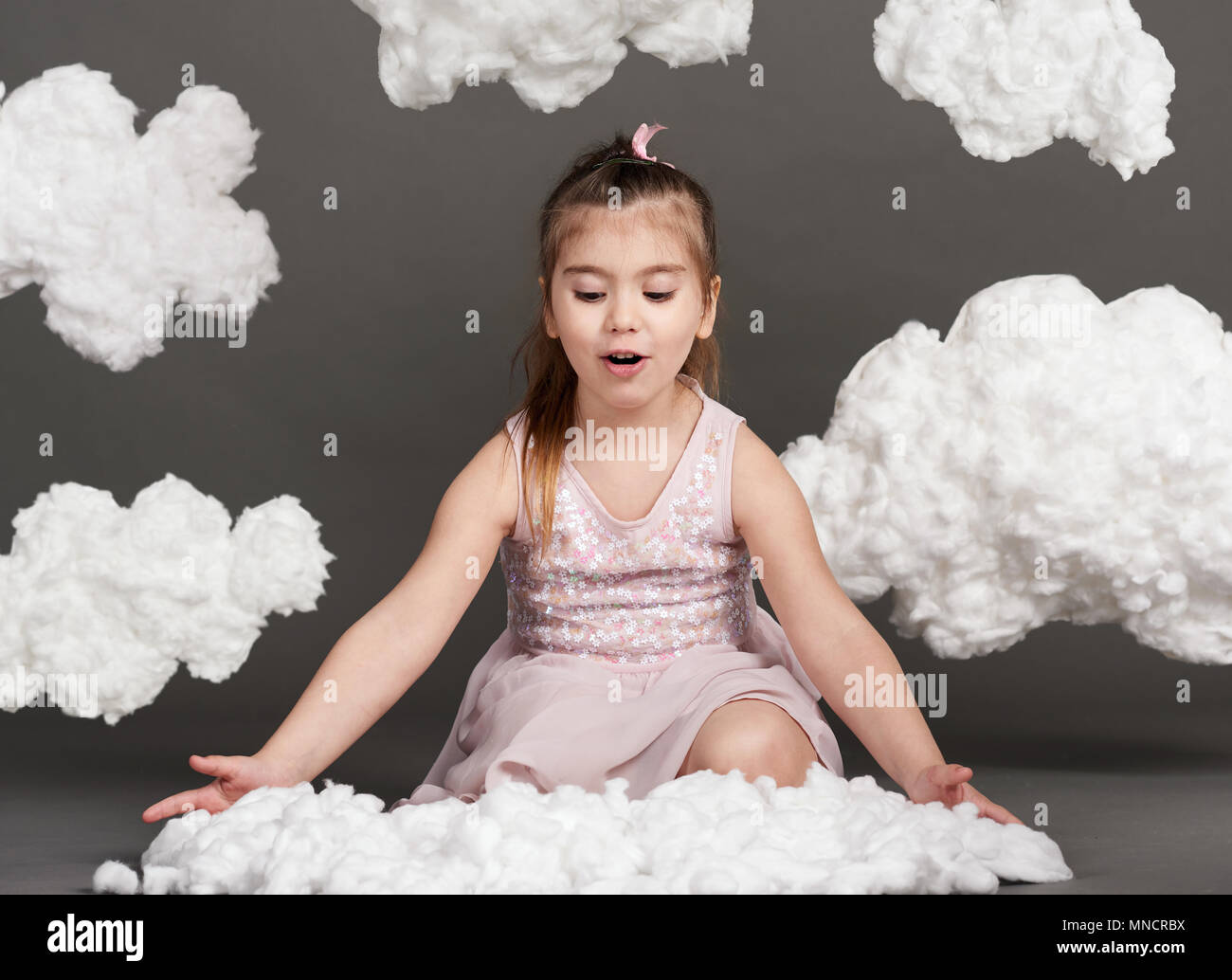 girl playing with clouds, shot in the studio on a gray background Stock ...