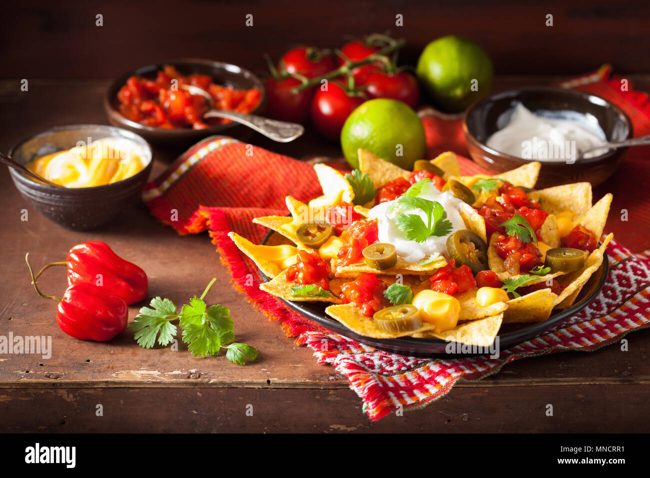 nachos loaded with salsa, cheese and jalapeno Stock Photo - Alamy