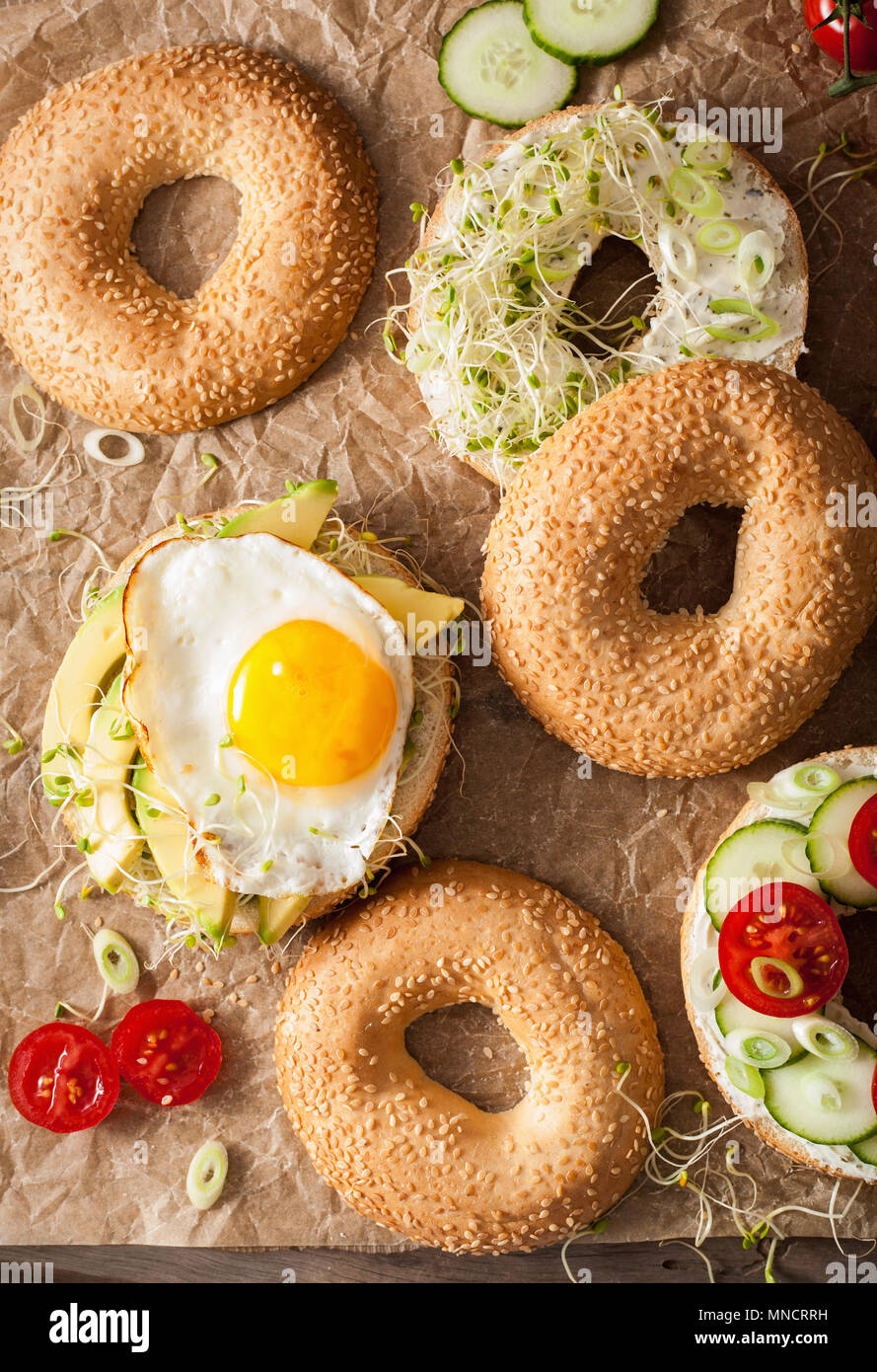 variety of sandwiches on bagels: egg, avocado, ham, tomato, soft cheese ...