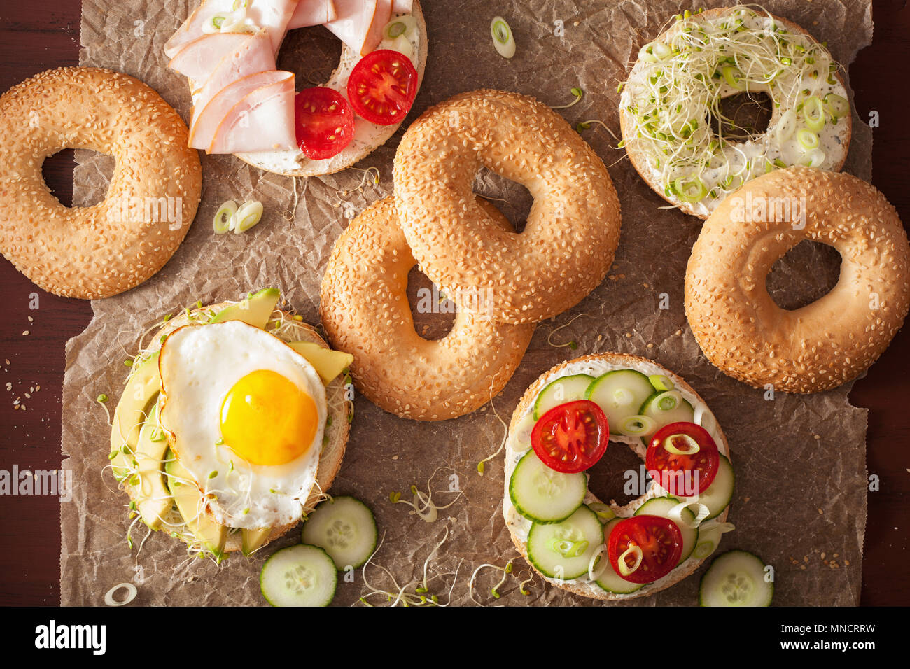 variety of sandwiches on bagels: egg, avocado, ham, tomato, soft cheese ...