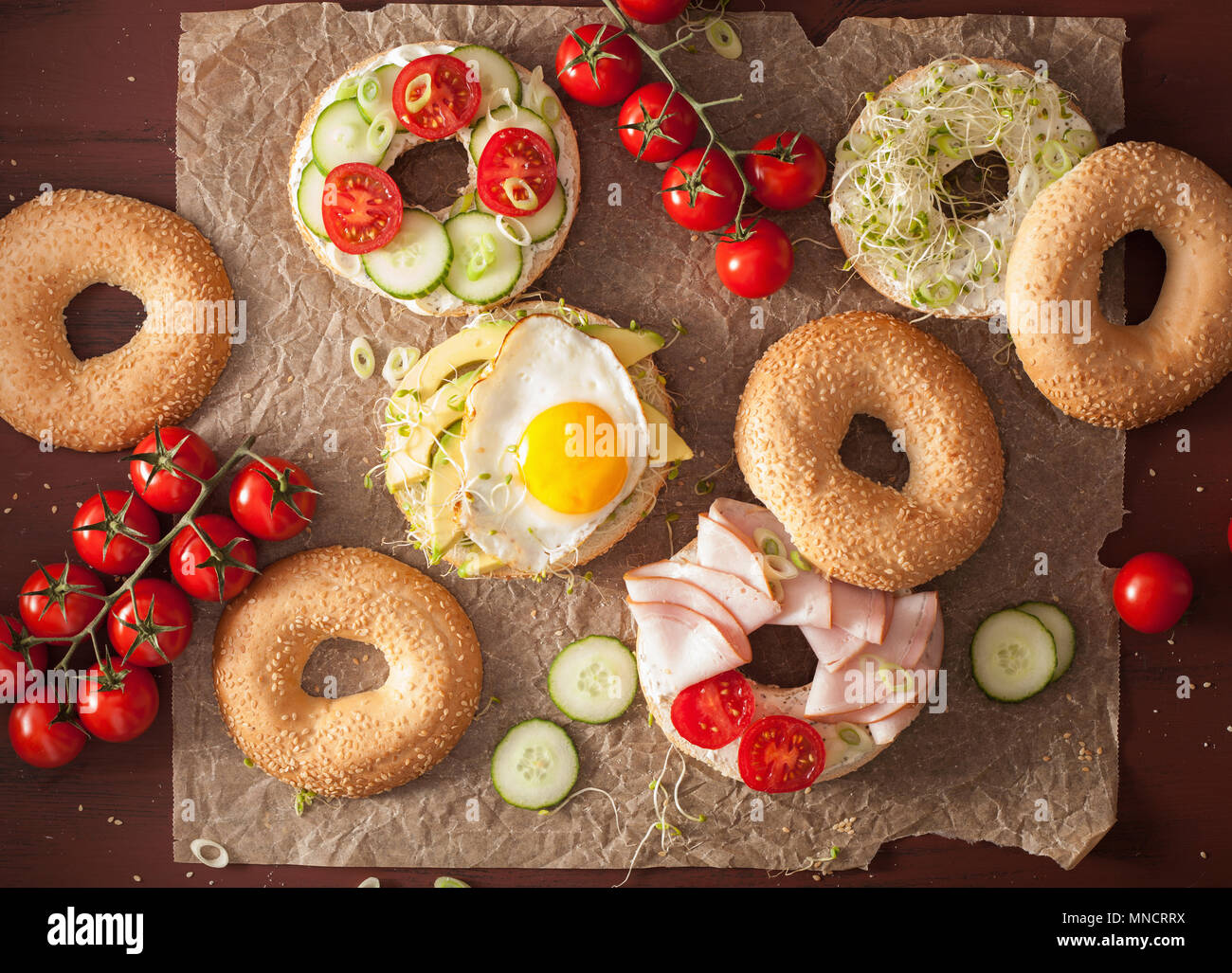 variety of sandwiches on bagels: egg, avocado, ham, tomato, soft cheese ...