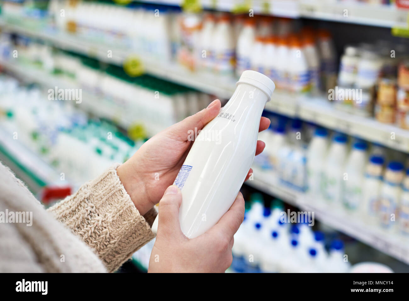 Buyer hands with a bottle of milk at the grocery store Stock Photo - Alamy
