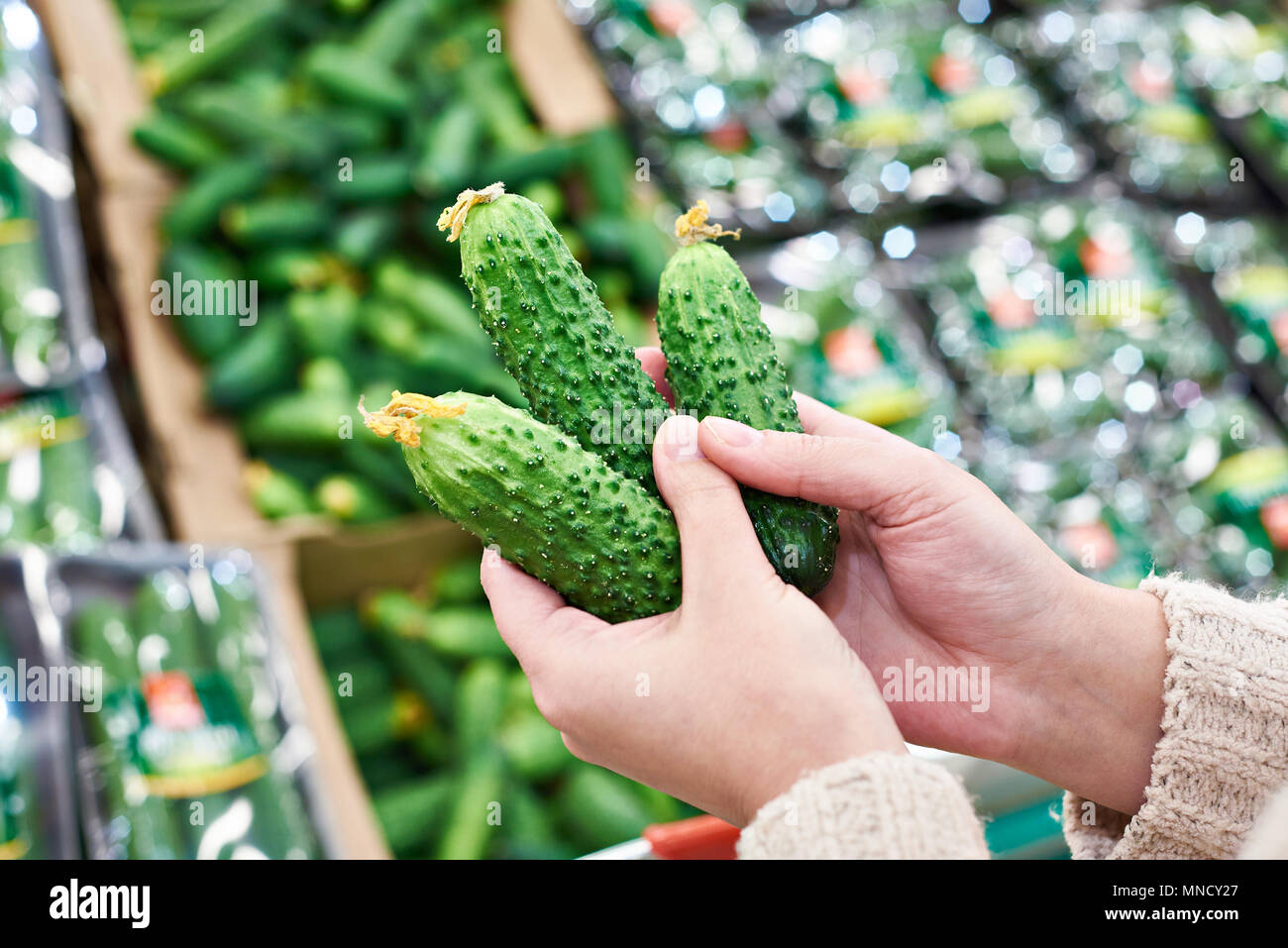Buyer hands with cucumbers in the store Stock Photo - Alamy