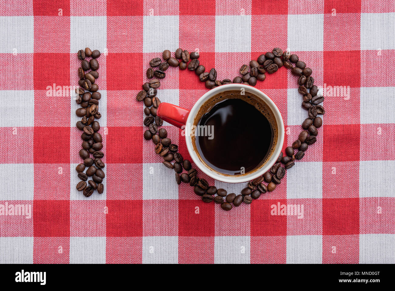 Red coffee cup placed inside coffee beans in heart shape, top view. Red ...