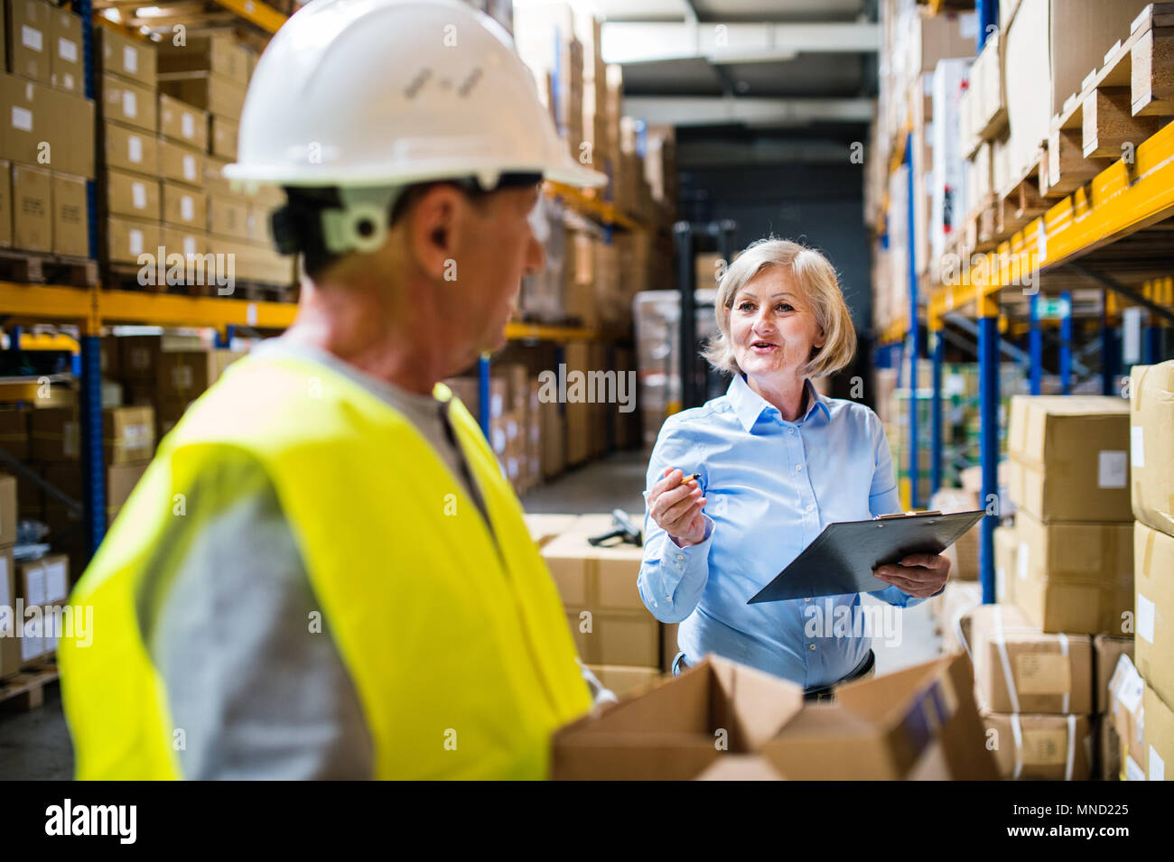 Senior woman manager and man worker working in a warehouse Stock Photo ...