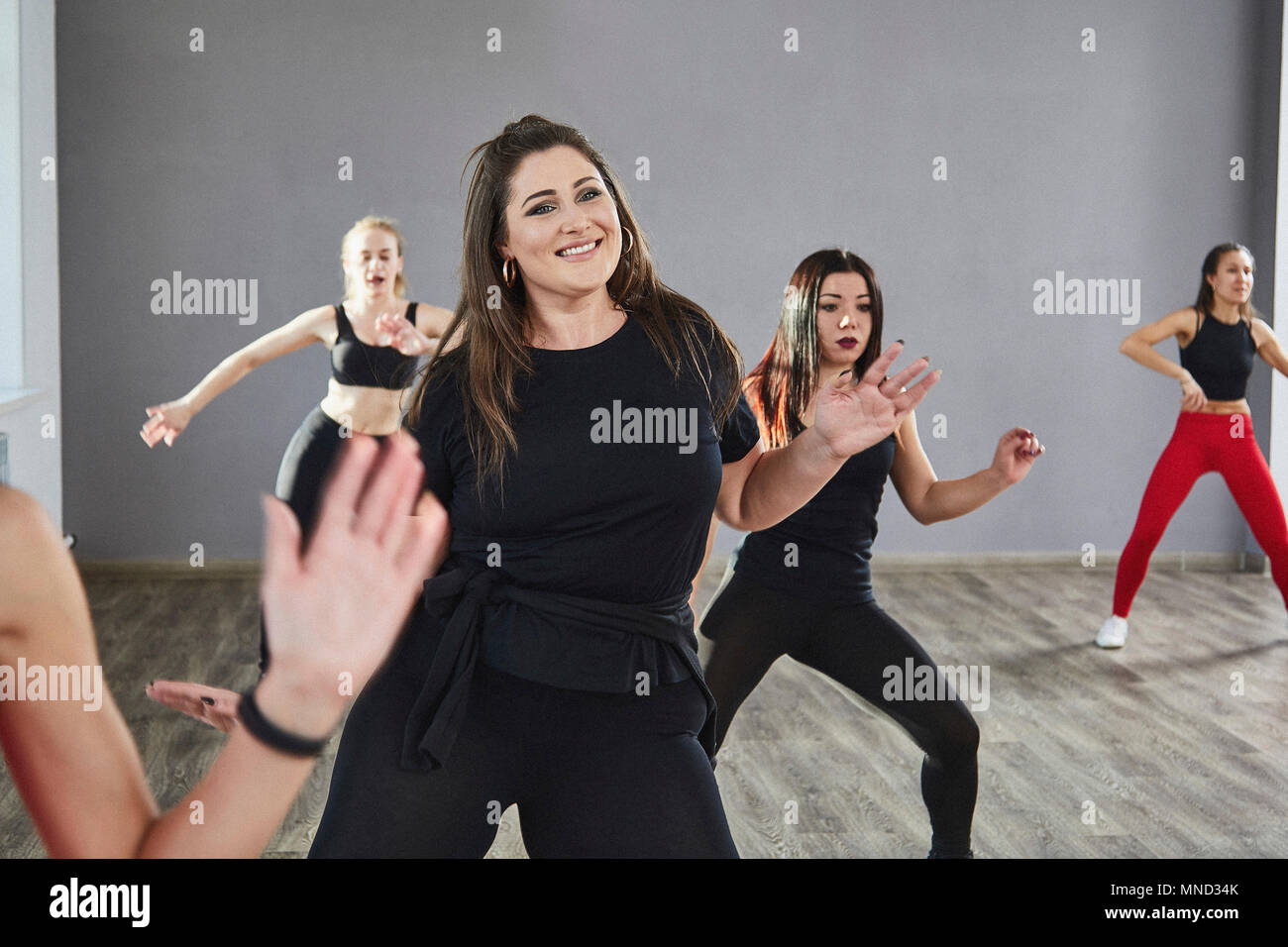 Smiling young woman practicing with friends in dance studio Stock Photo ...