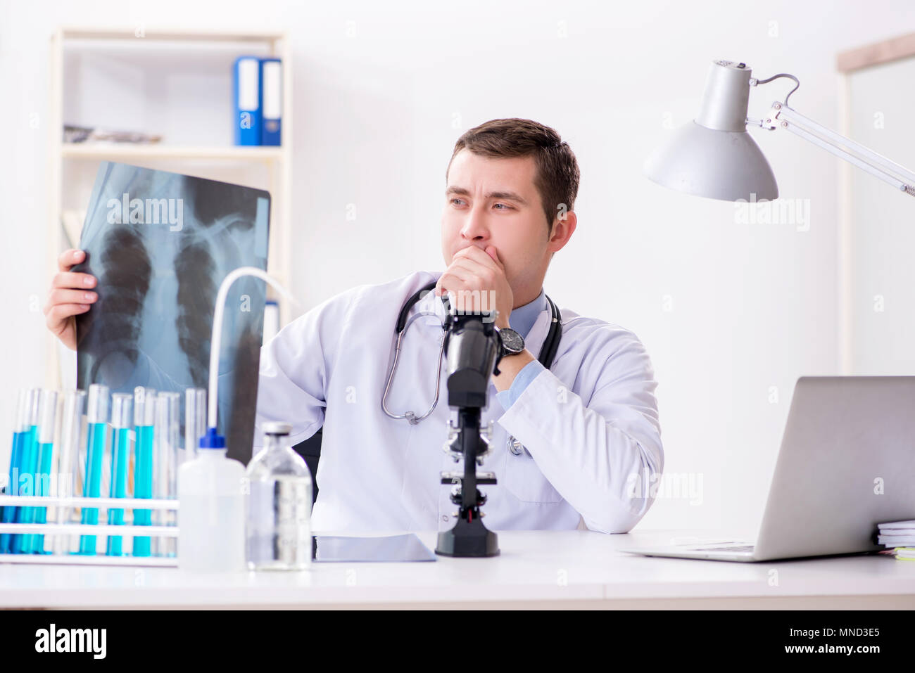 Male doctor looking at lab results in hospital Stock Photo - Alamy