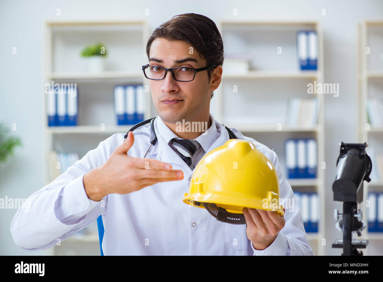 Safety doctor advising about wearing hard hat Stock Photo - Alamy