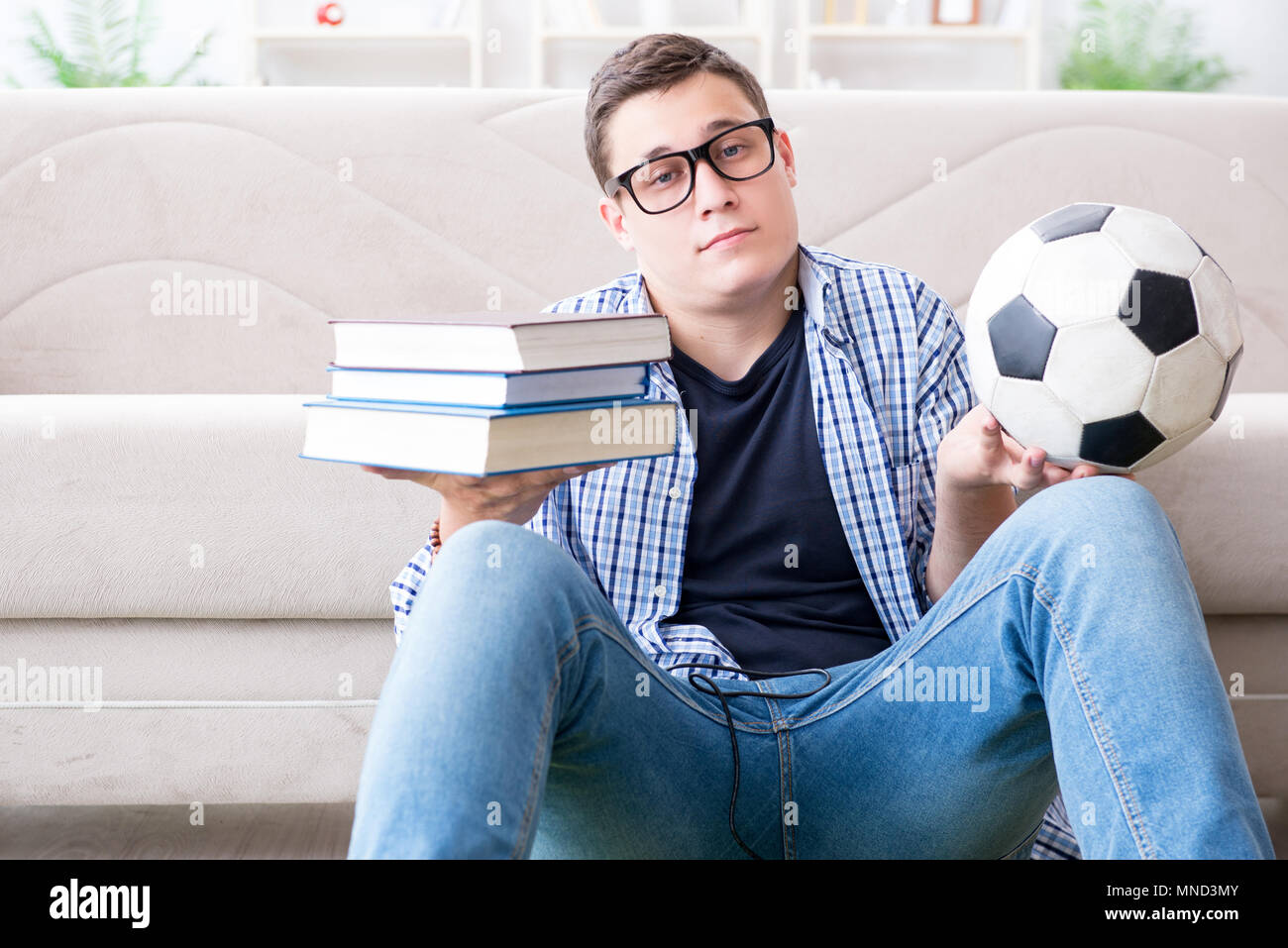 Young student trying to balance studying and playing football Stock ...
