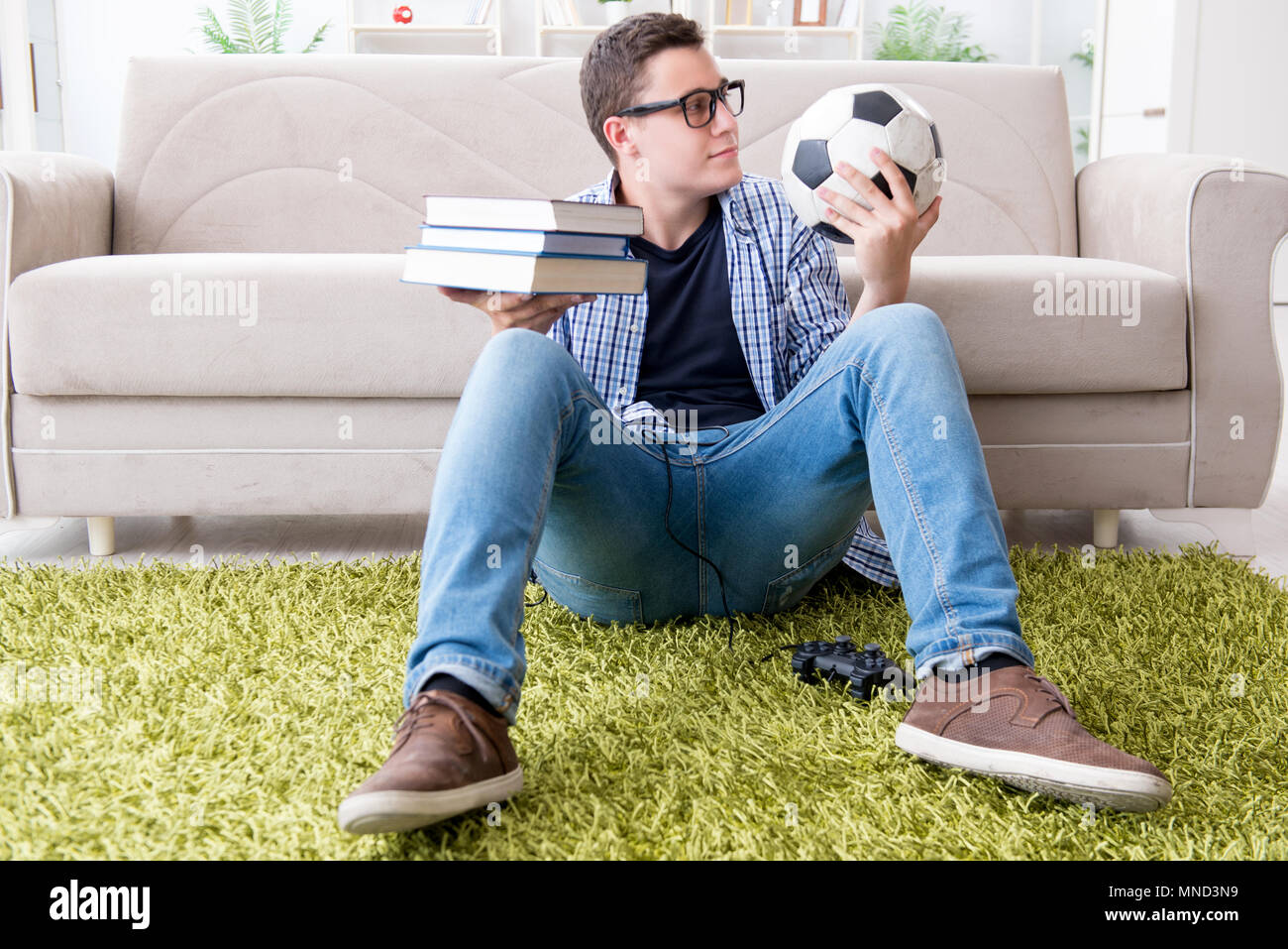 Young student trying to balance studying and playing football Stock ...