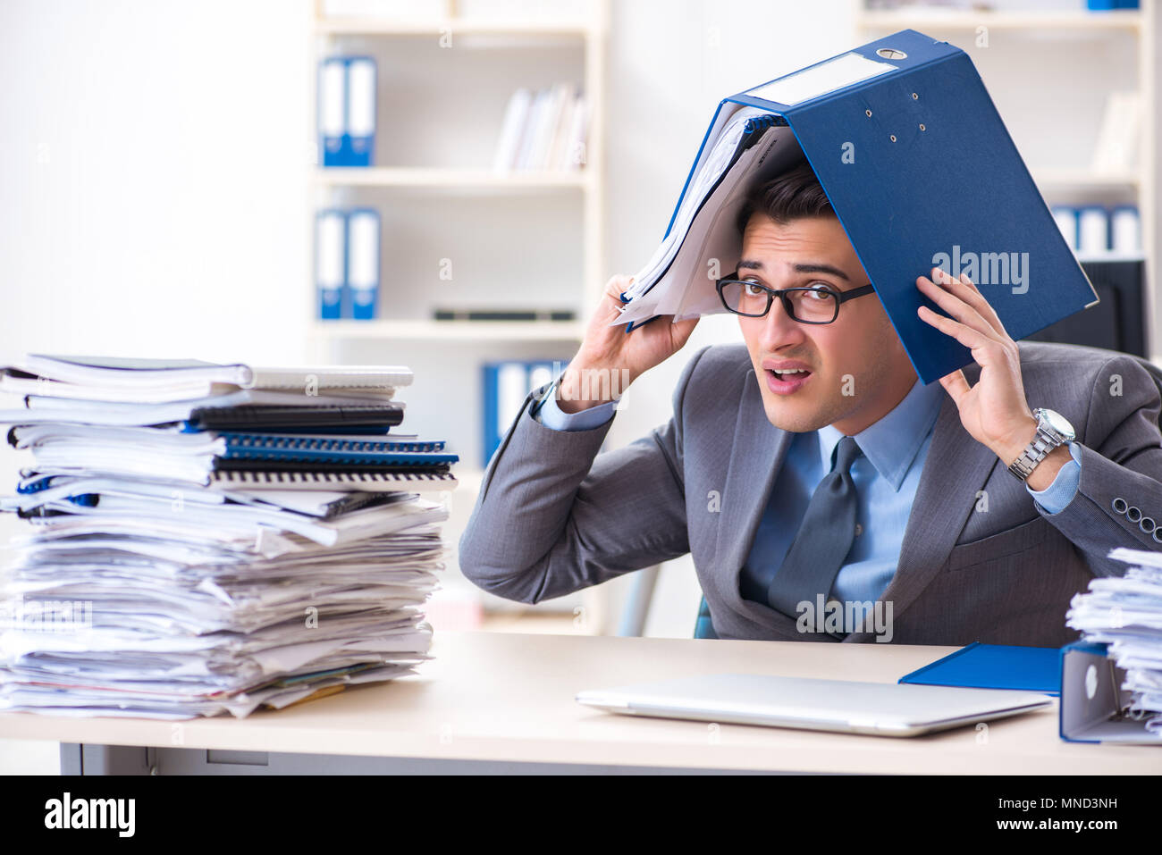 Overloaded with work employee under paperwork burden Stock Photo - Alamy