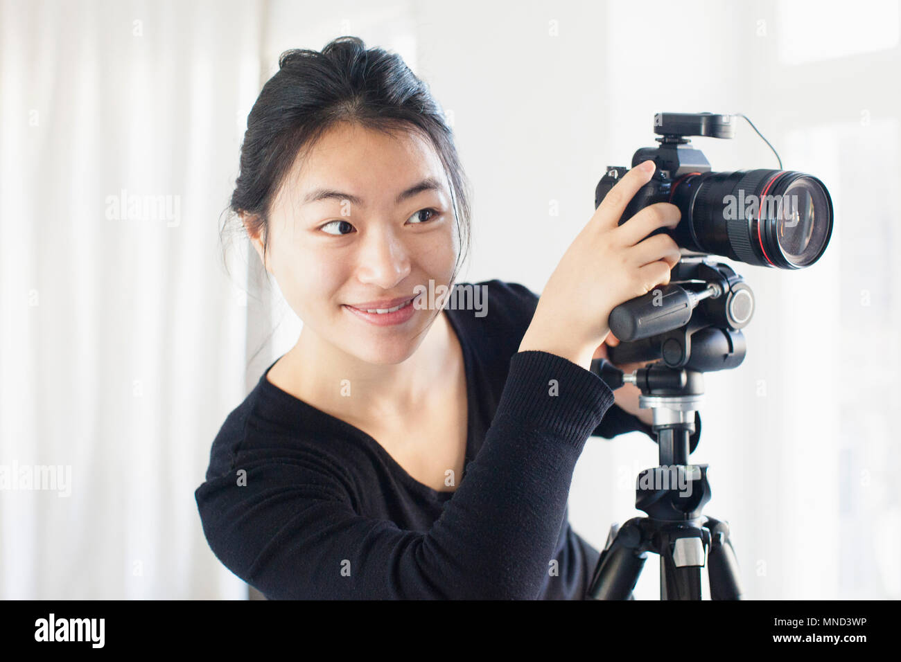 Smiling young woman photographing with camera Stock Photo - Alamy