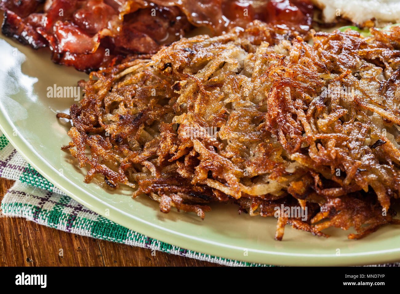 Hash browns. Potato pancakes with crispy fried bacon and fried egg ...