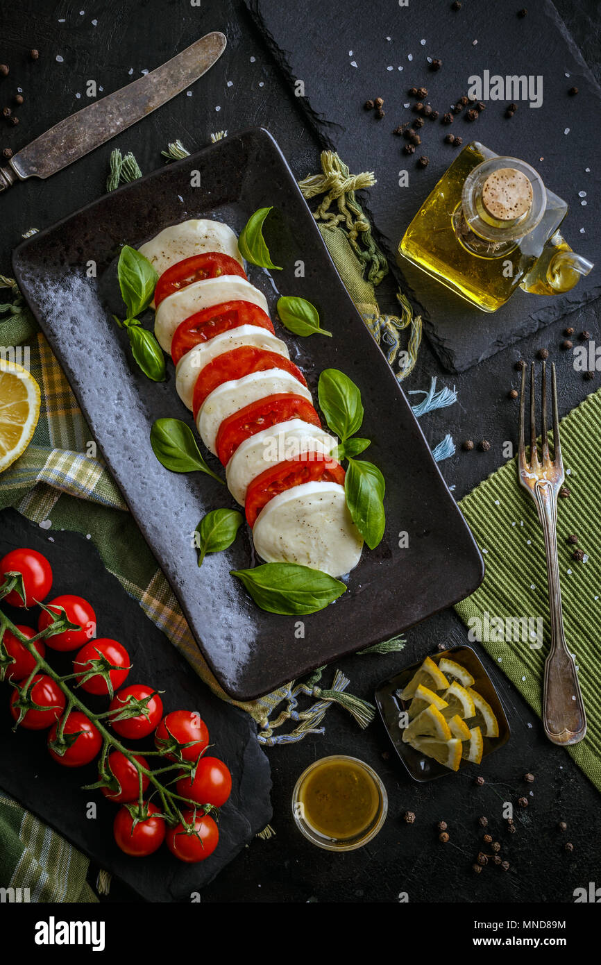 Still life of delicious caprese salad on black background Stock Photo ...