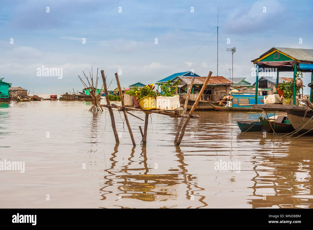 A wooden stilted platform next to a houseboat in Cambodia's floating ...