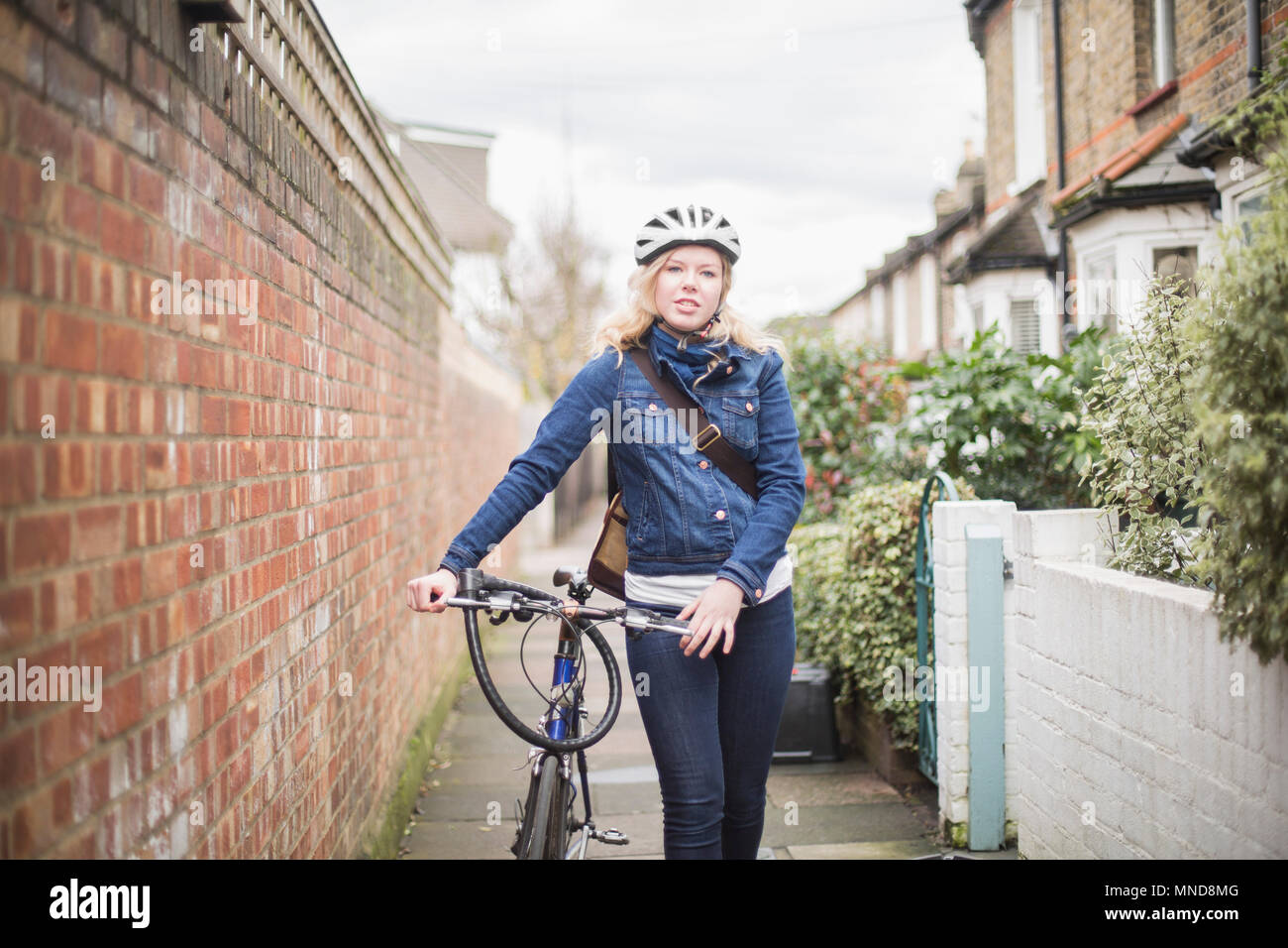Woman walking her bicycle hi-res stock photography and images - Alamy