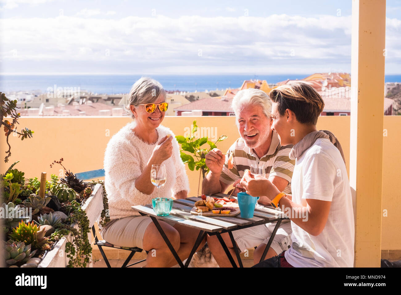 three people different ages eating and enjoying together the rooftop ...
