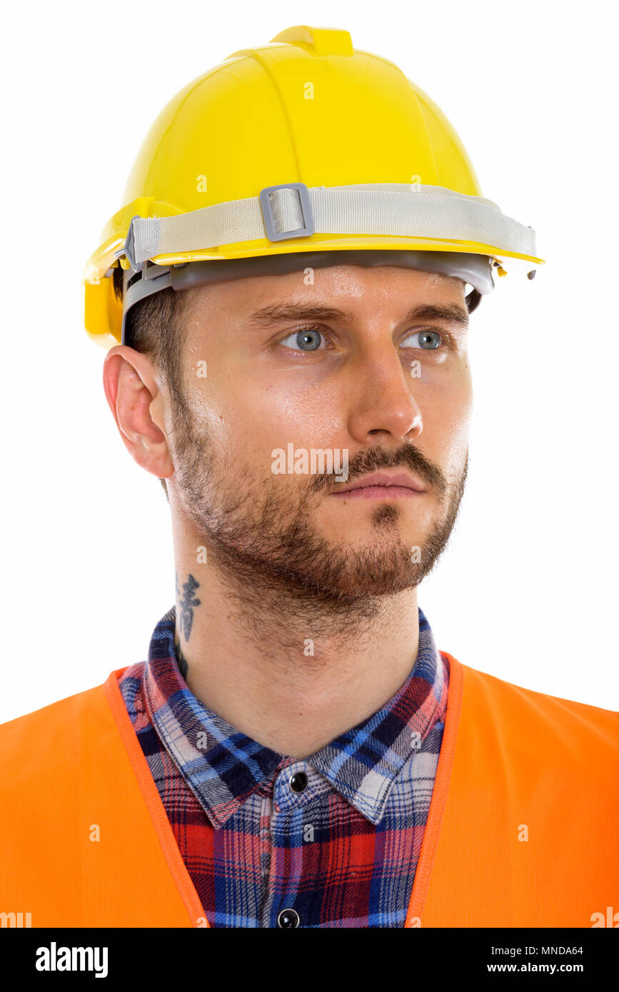 Face of young man construction worker thinking while looking at ...