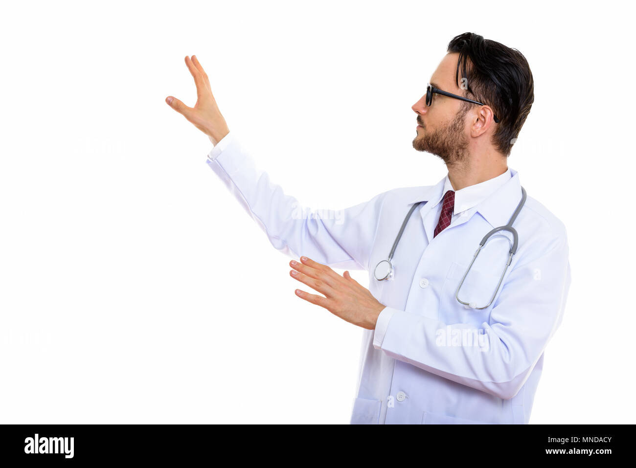 Profile view of young man doctor showing something on the wall Stock ...