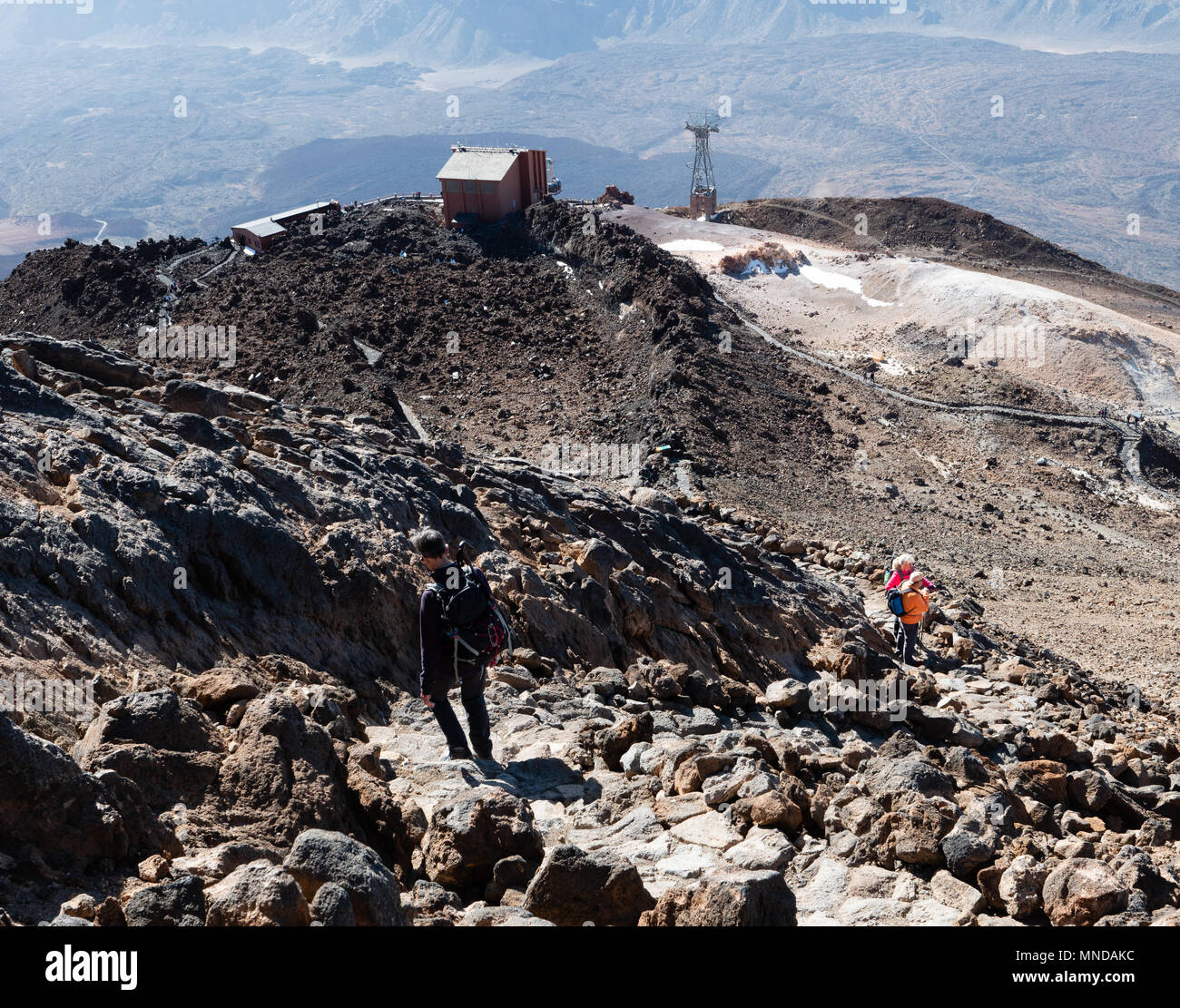 Climber descending the steep path from the summit cone of active ...